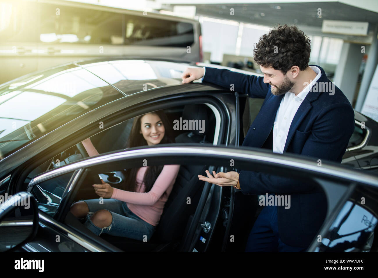 Dealer showing a new car model to the potential customer Stock Photo ...