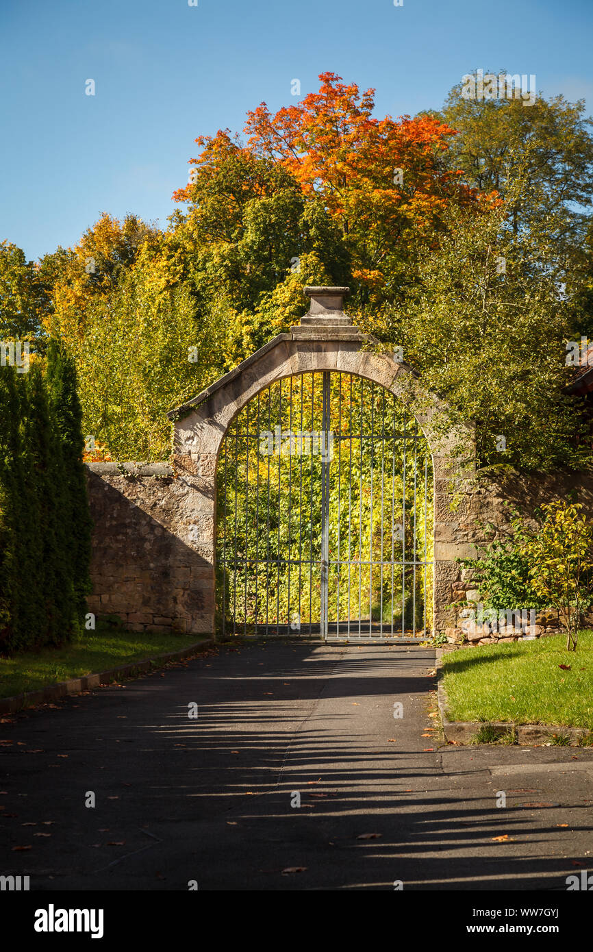 A stone gateway with a metal gate, closed Stock Photo - Alamy