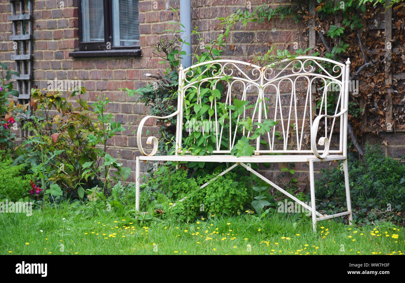 Old metal bench in a garden Stock Photo - Alamy