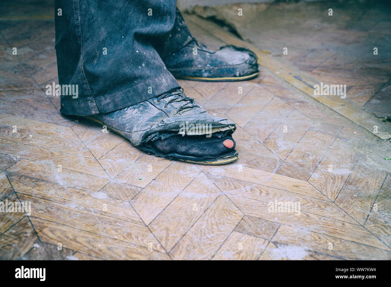 Old torn boots on the man's feet. Boots with holes. Selective focus ...