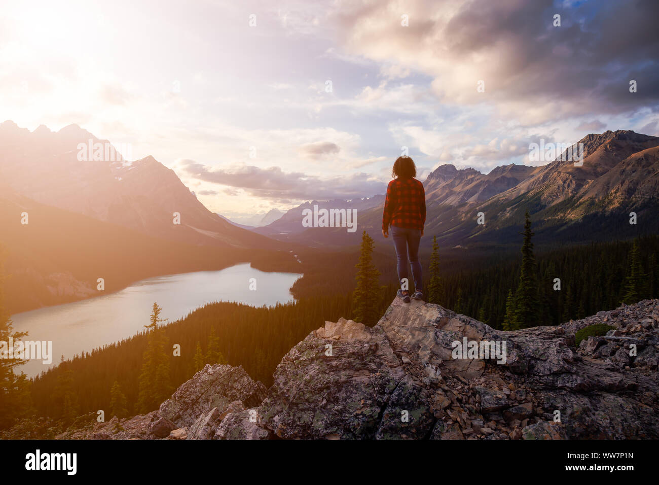 Adventurous girl standing on the edge of a cliff overlooking the ...