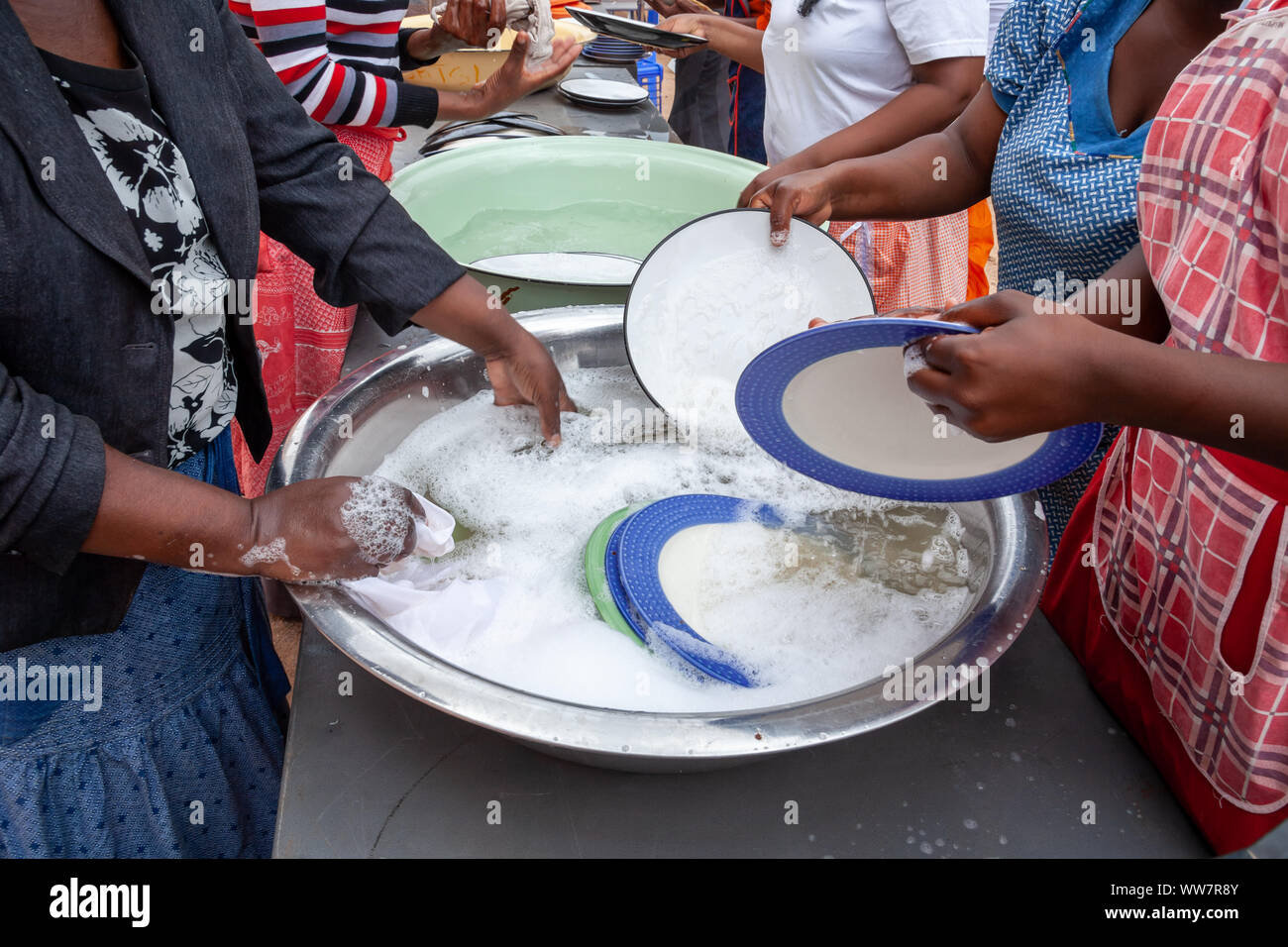 Group of African woman washing dishes on the table Stock Photo - Alamy