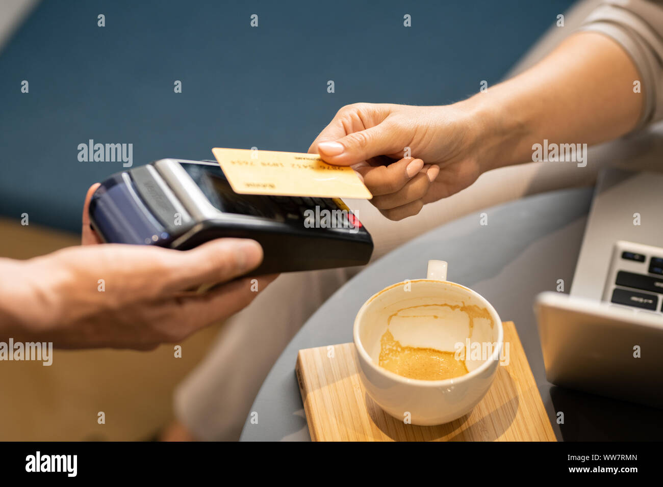 Female hand holding plastic card over electronic payment machine held ...