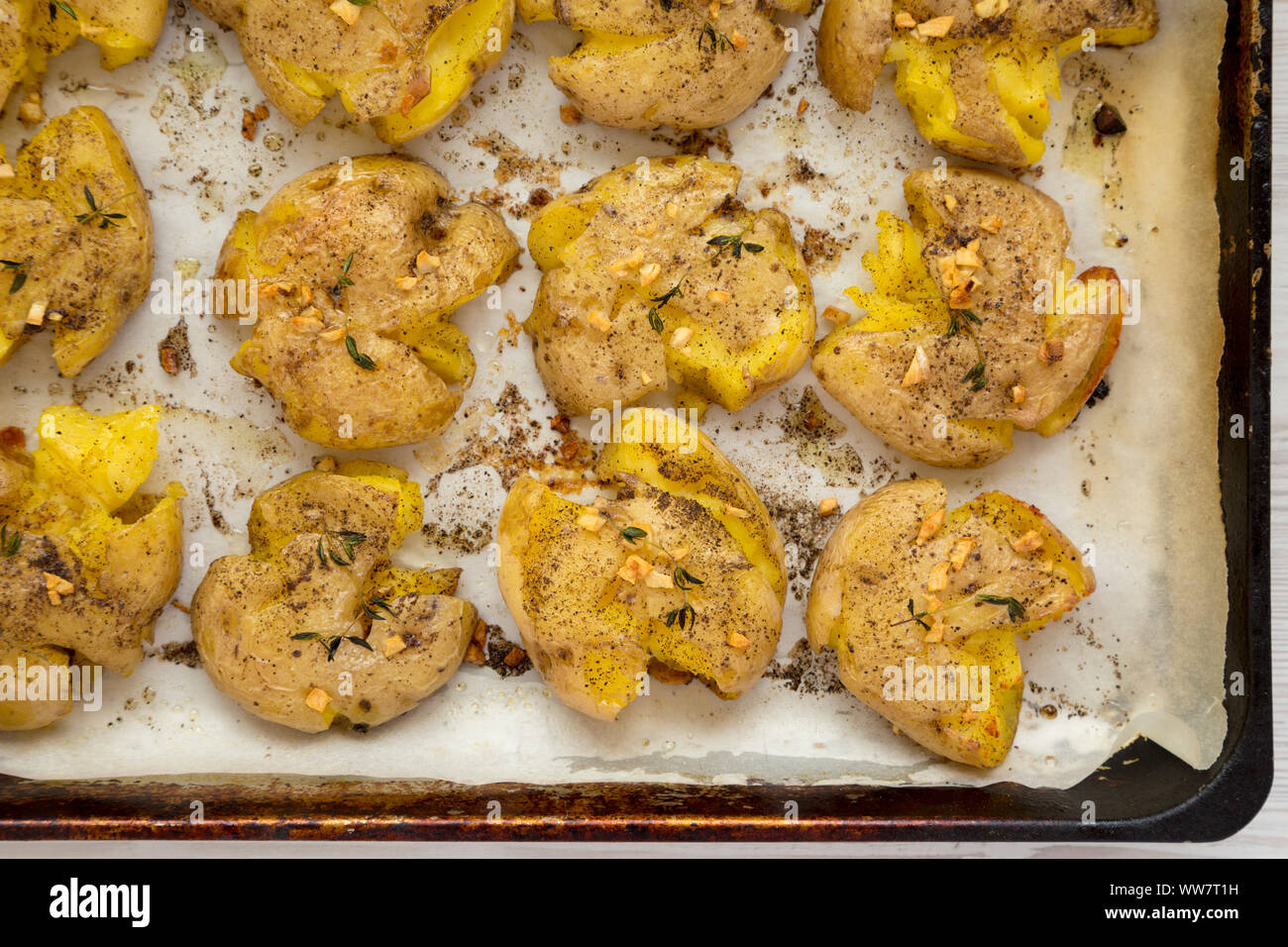 Homemade garlic thyme smashed potatoes on a baking sheet, top view ...