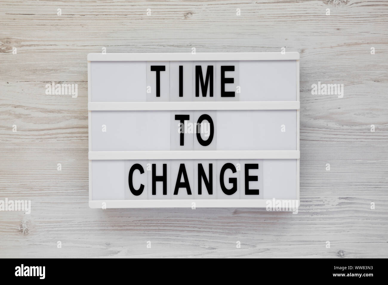 'Time to change' words on a modern board over white wooden surface, top ...