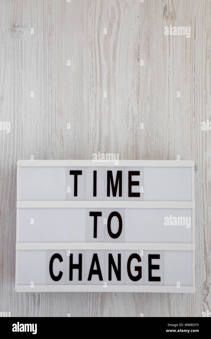 'Time to change' words on a modern board over white wooden surface, top ...