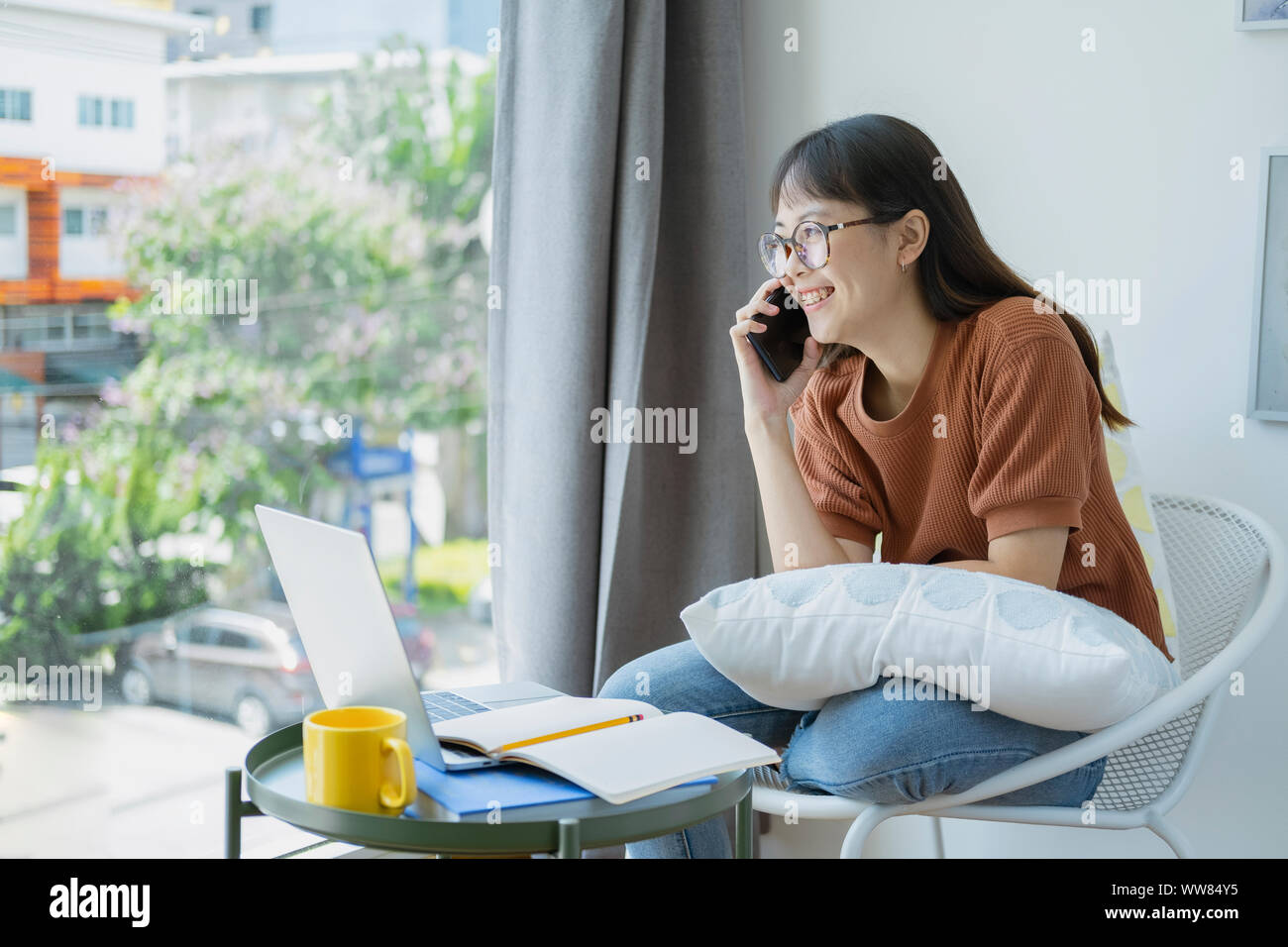 Happy young girl talking on the phone at home, making answering call ...
