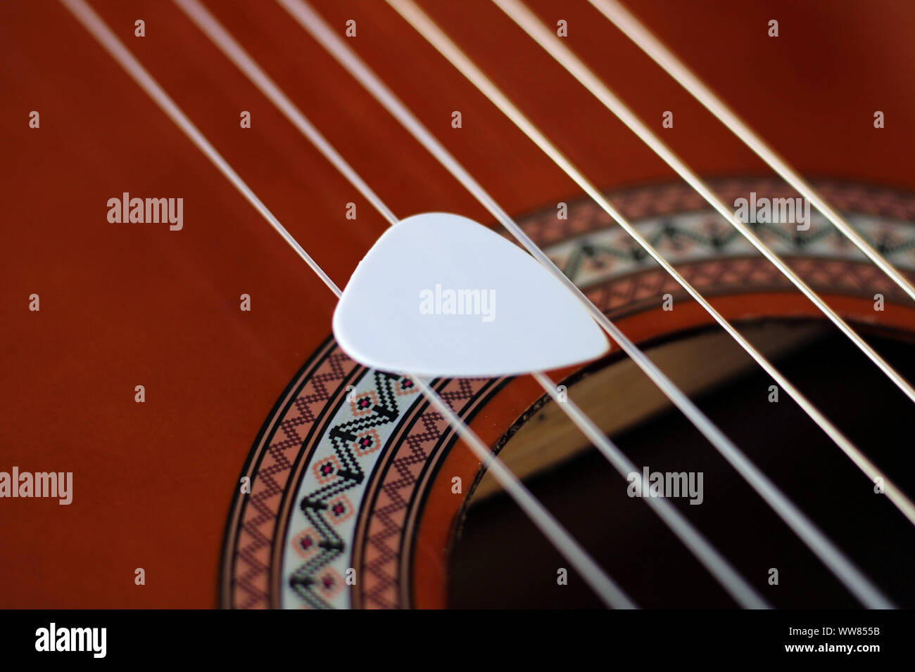 Music Concept: Guitar pick on the fingerboard of a brown guitar Stock ...