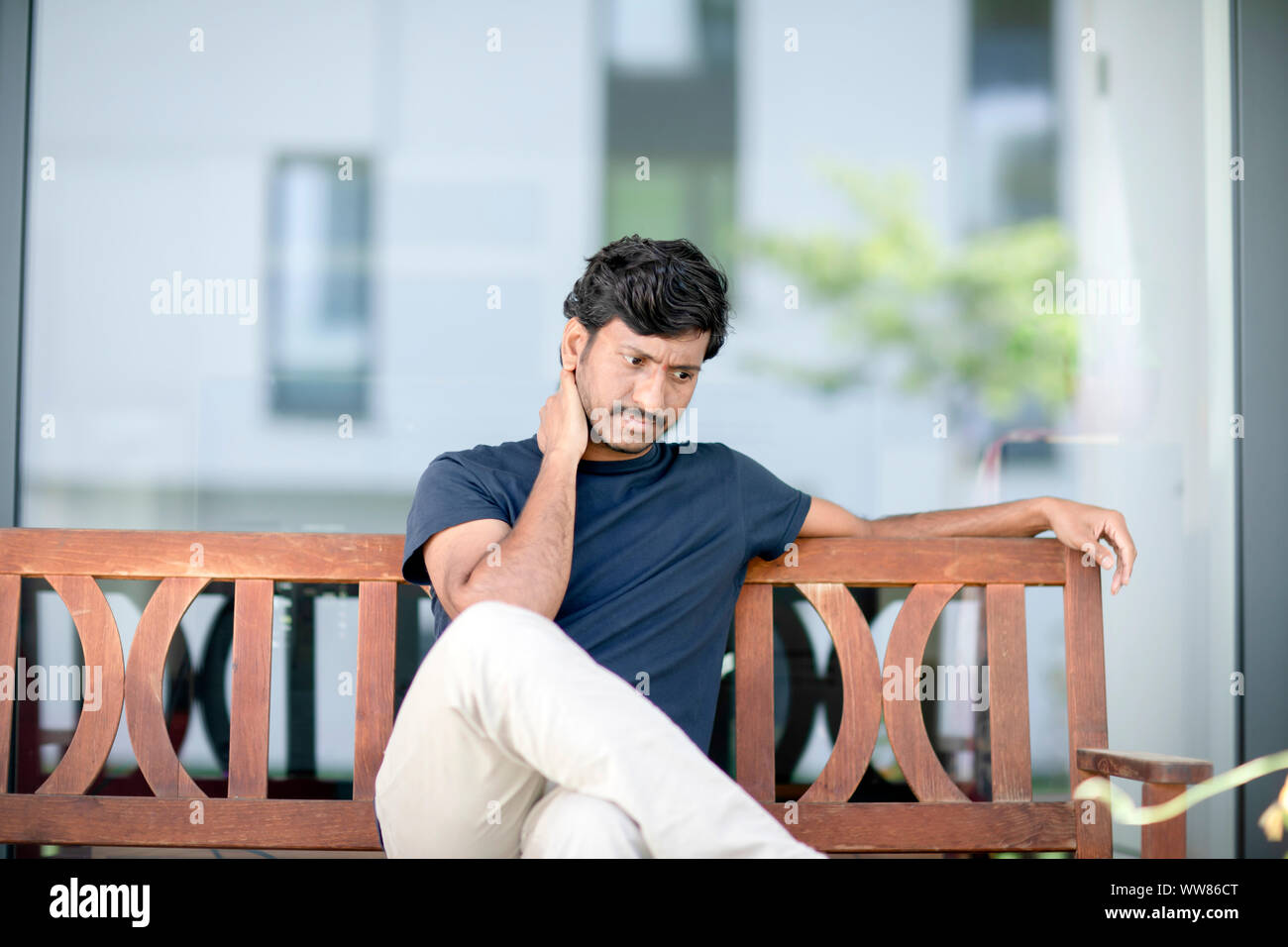 young man sitting on a bench thinking Stock Photo - Alamy