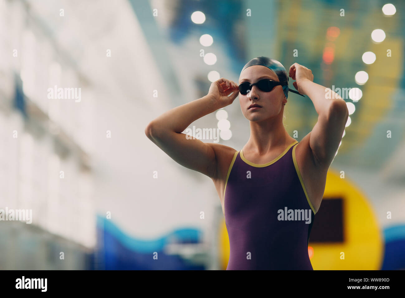 Young woman swimmer getting ready for competition and swim in swimming ...