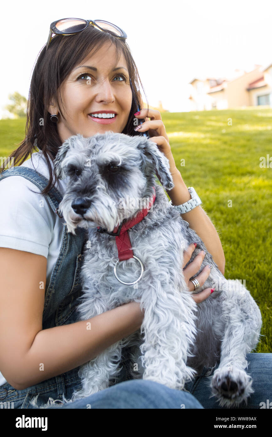Portrait of a happy caucasian woman who hugs her beloved dog and ...