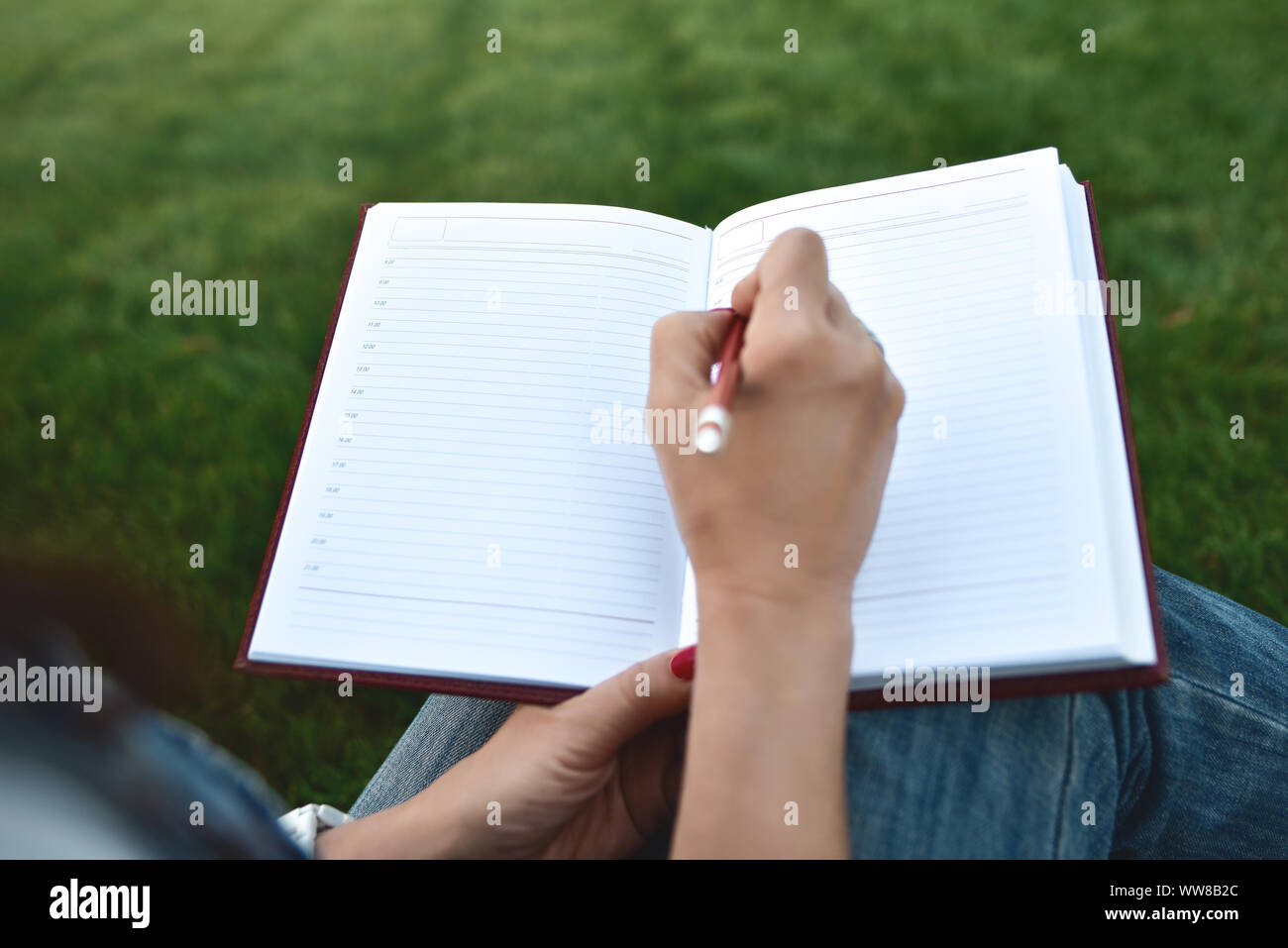 close up young women writing on notebook in park. education and ...