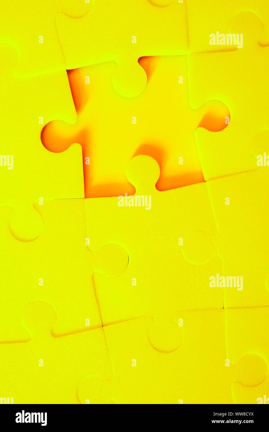 Multiple yellow puzzle pieces put together without one piece. View from ...