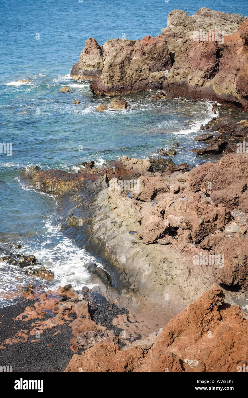 Volcanic rock diving into the ocean on the island of Lanzarote Stock ...
