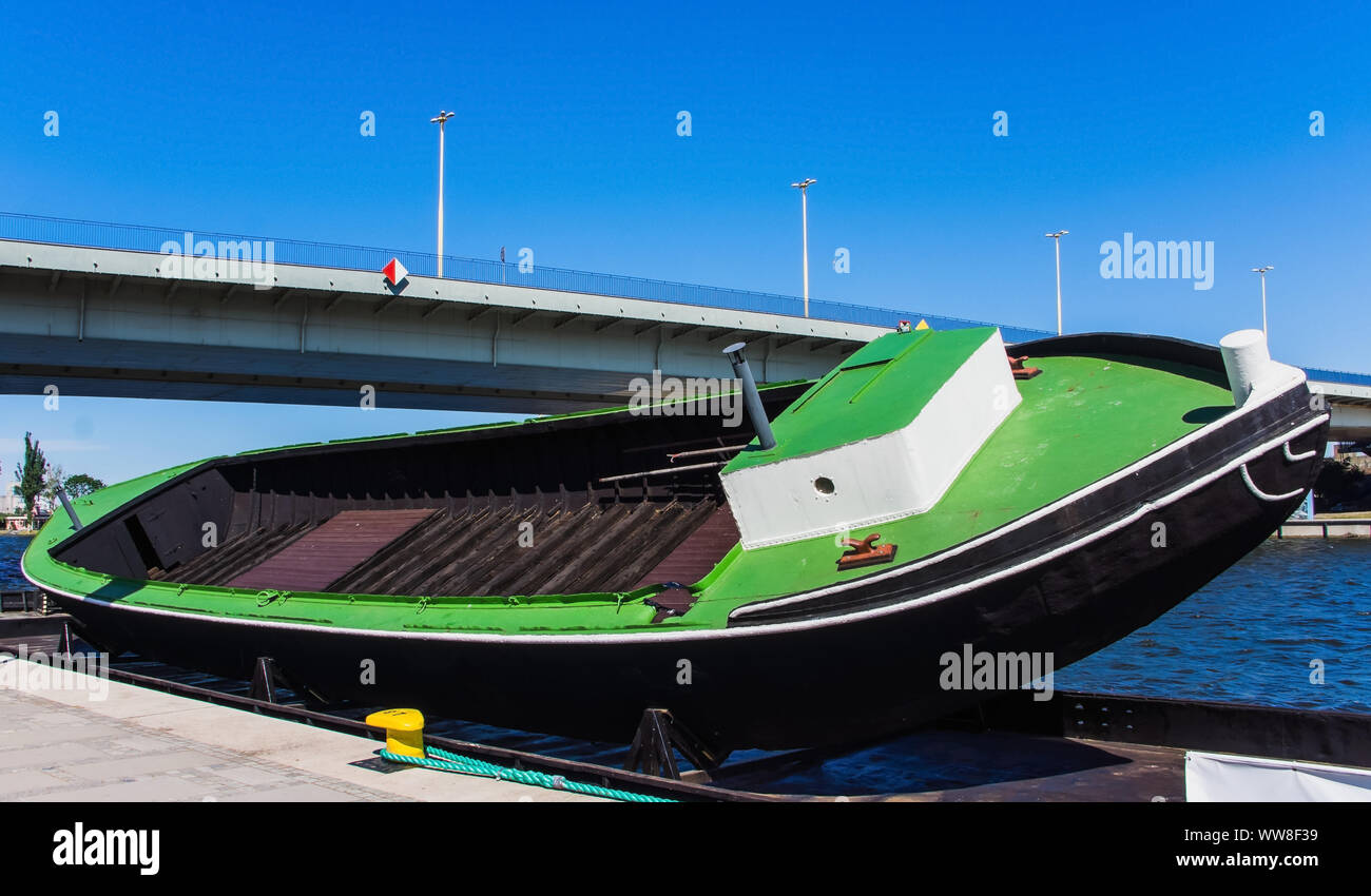 Large tilted empty boat on docking ramp on the embankment of Odra River ...