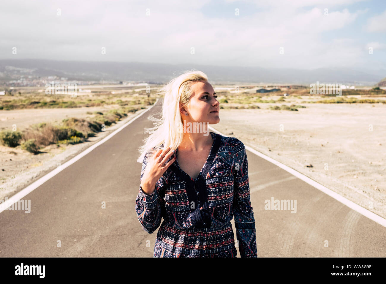 beautiful lonely blonde caucasian young girl walk in fashion dress in a ...