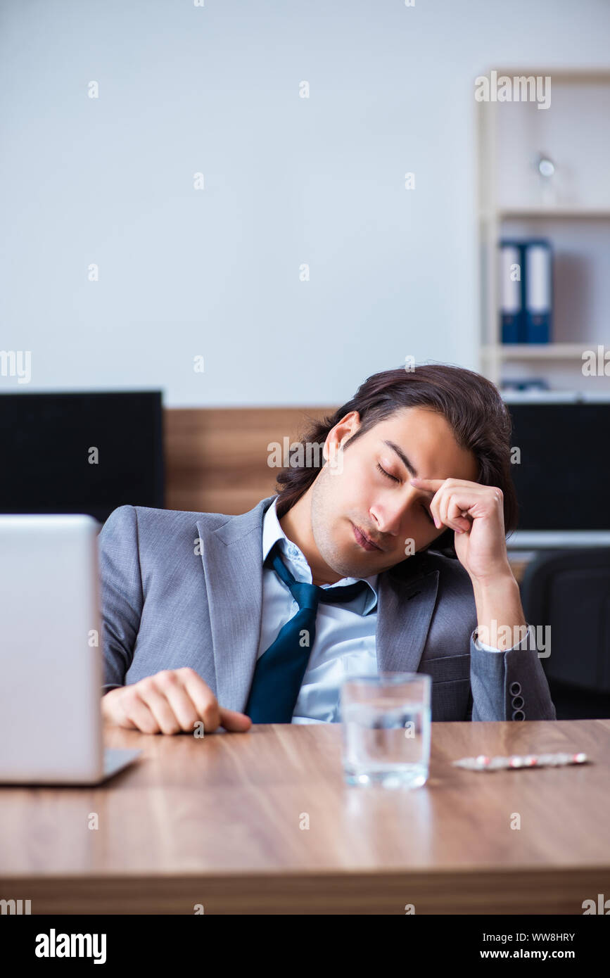 The sick male employee suffering in the office Stock Photo - Alamy