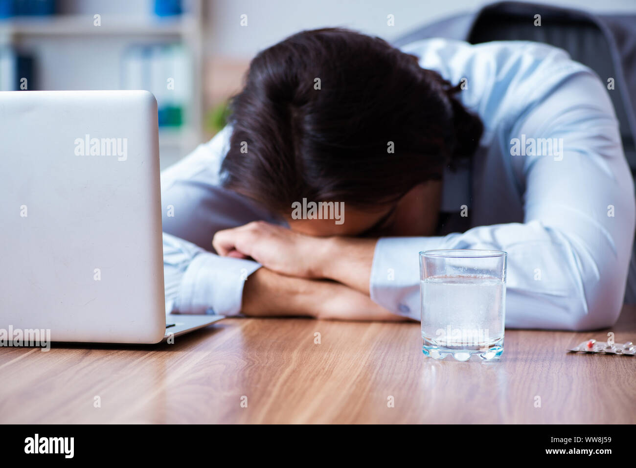 The sick male employee suffering in the office Stock Photo - Alamy