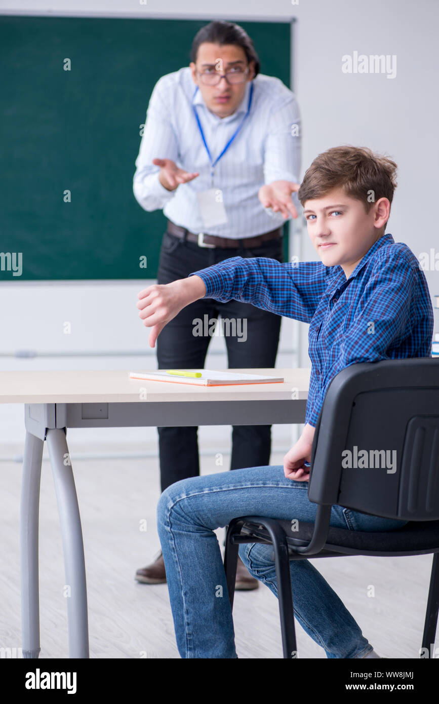 The young male teacher and boy in the classroom Stock Photo - Alamy
