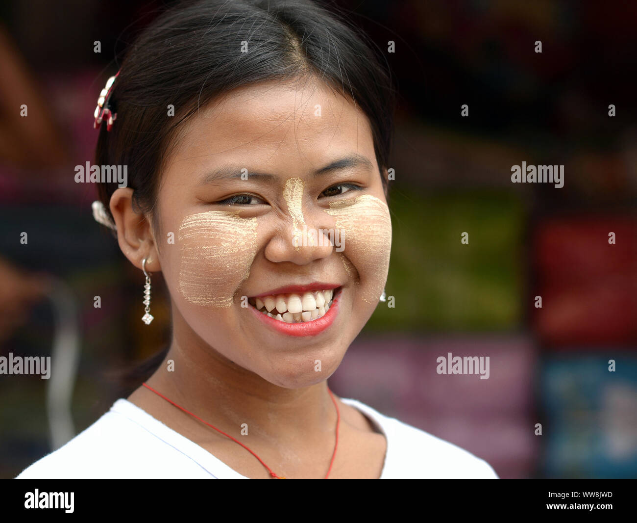 Young Burmese woman with patches of yellowish-white traditional thanaka ...