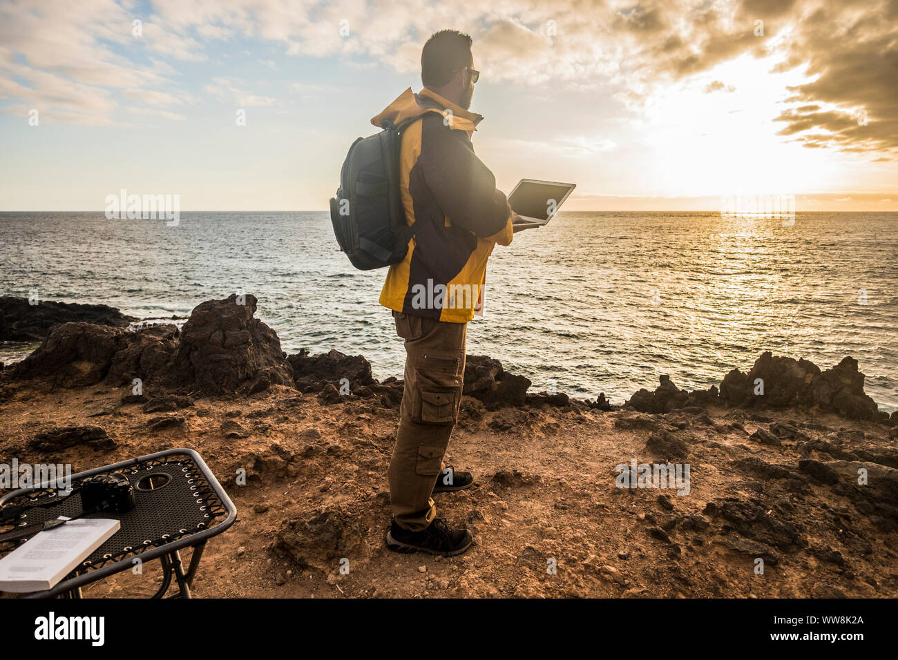 Digital nomad traveler man at work lokking an amazing golden sunset on ...