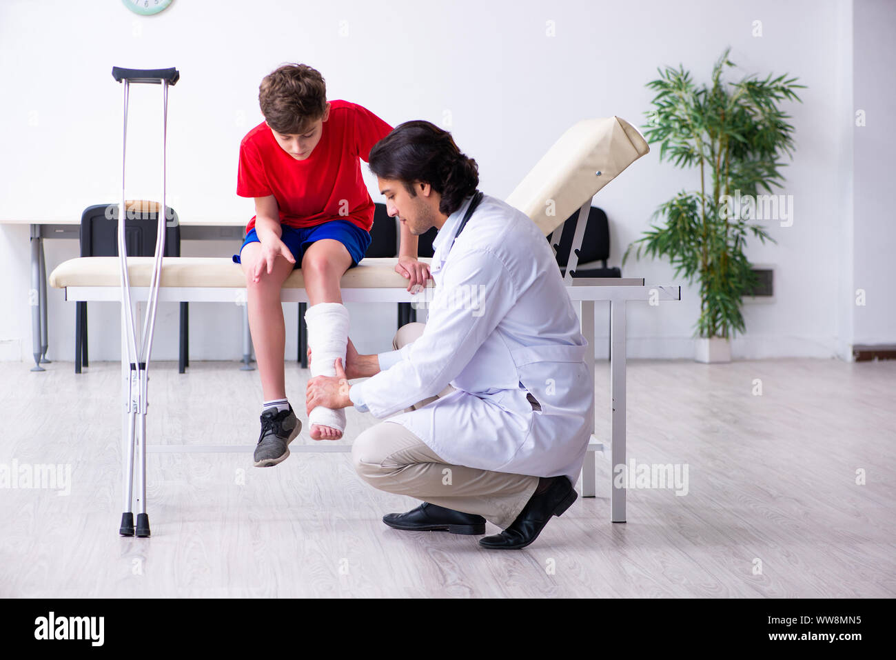 The leg injured boy visiting young doctor traumatologist Stock Photo ...