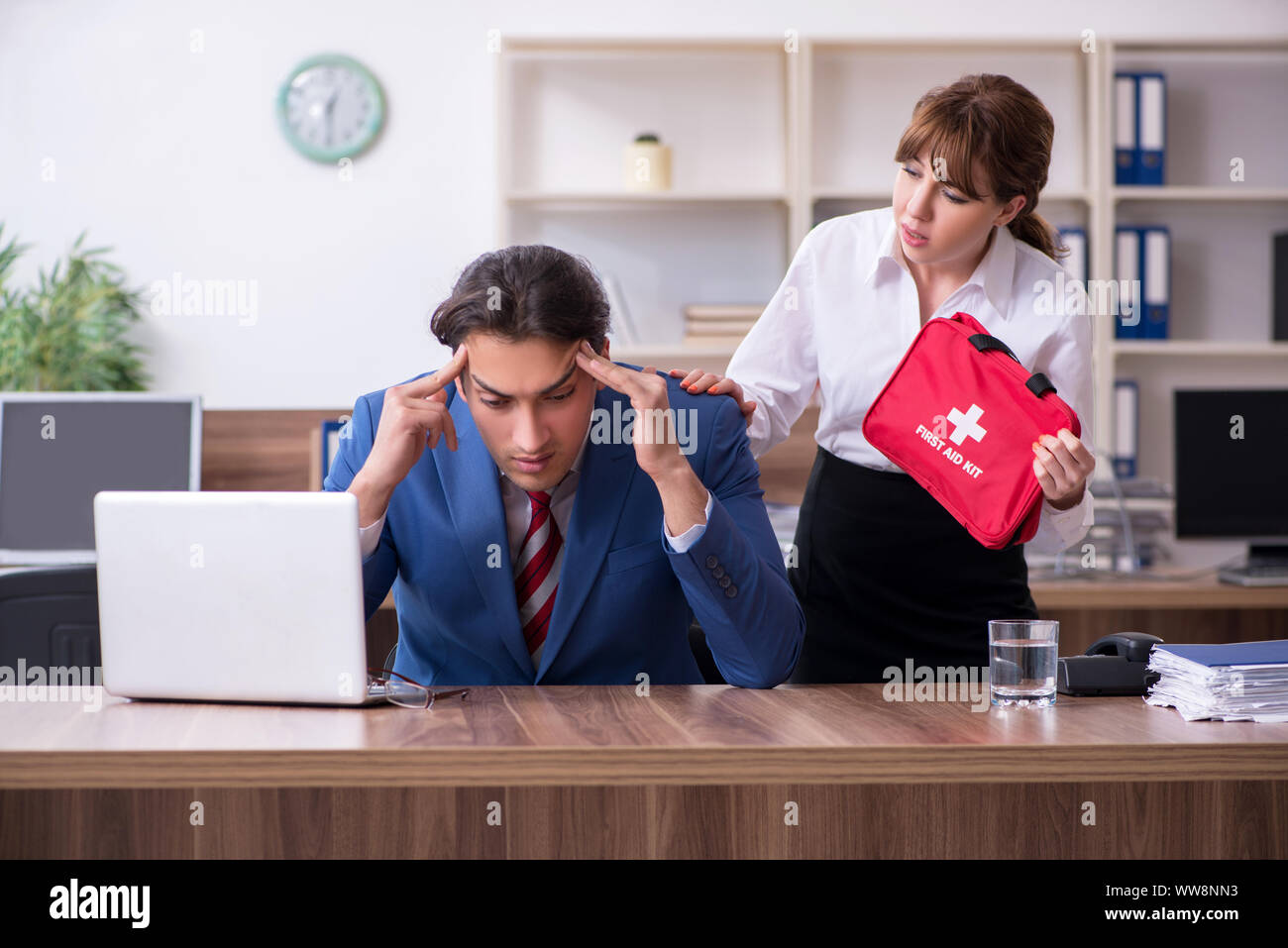 Employee receiving first aid in office Stock Photo - Alamy