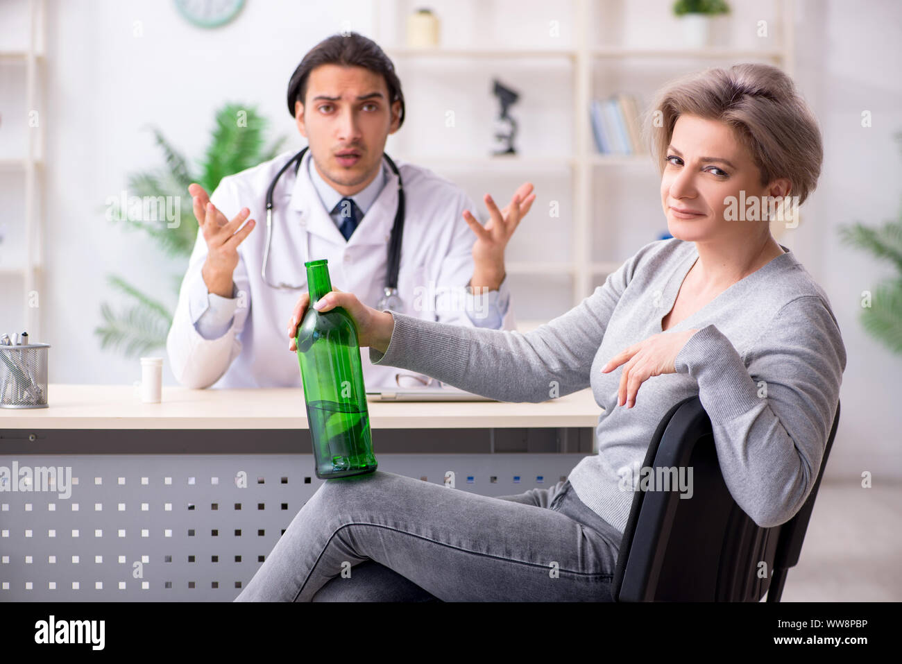 The female alcoholic visiting young male doctor Stock Photo - Alamy