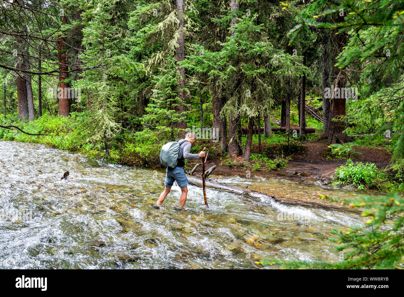 Man crossing river strong current ford on Conundrum Creek Trail in ...