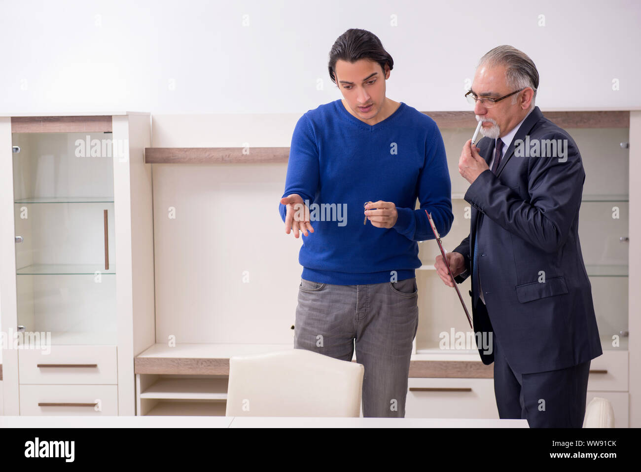 The male real estate agent and male client in the apartment Stock Photo ...