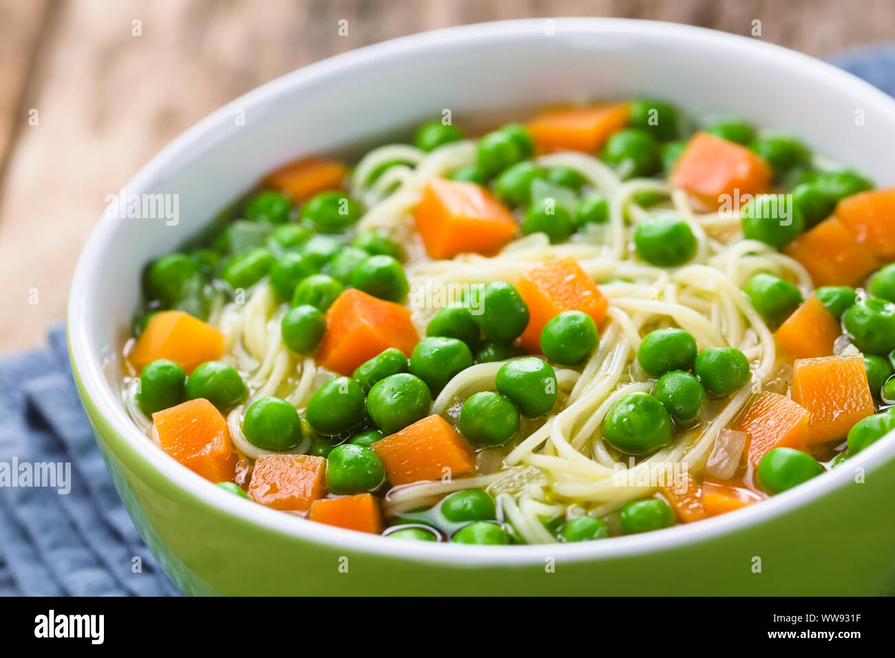 Fresh homemade vegetable noodle soup with carrot, peas, onion and angel ...
