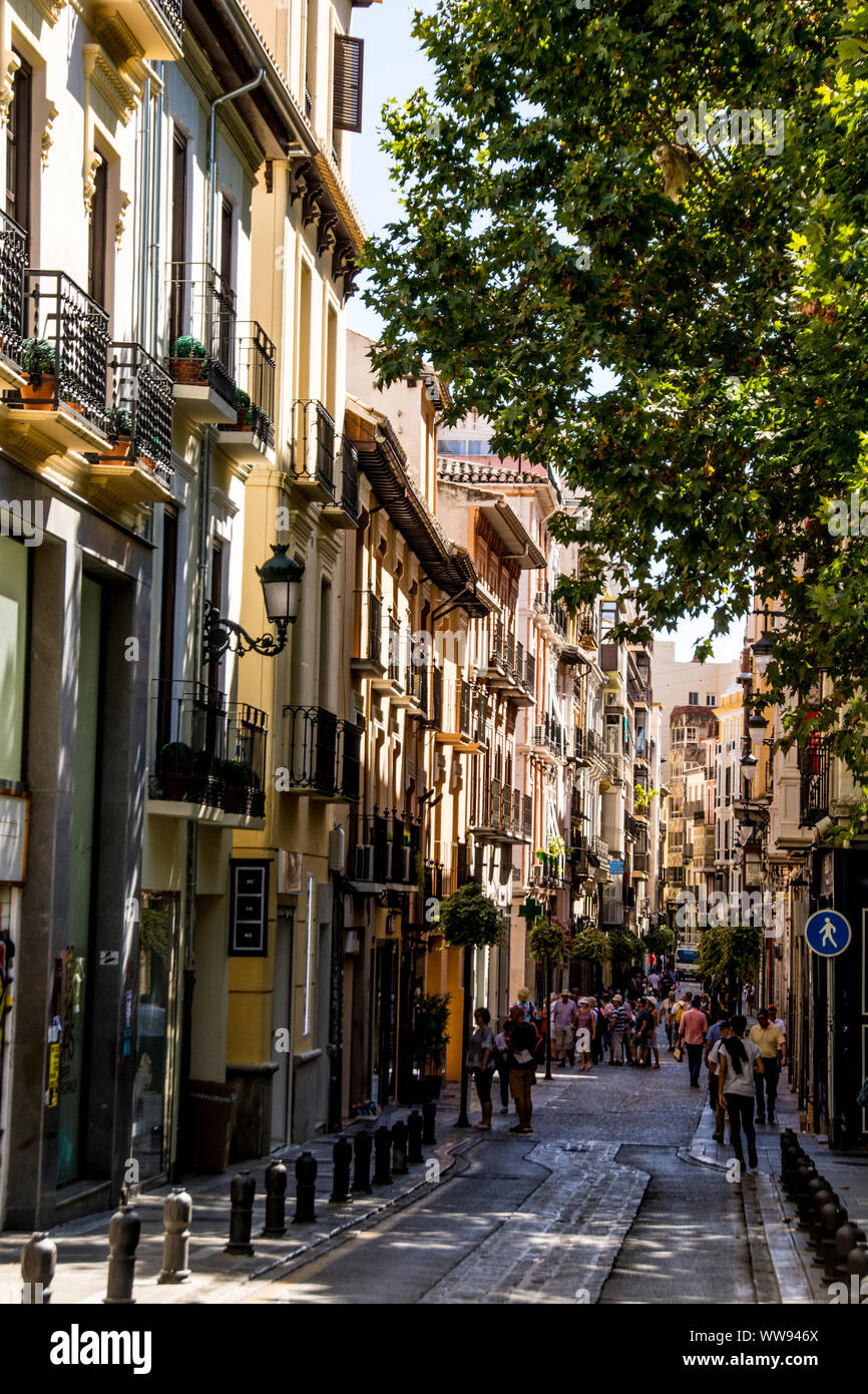 Busy street in Granada, Spain. Lined with shops, cafes and restaurants ...