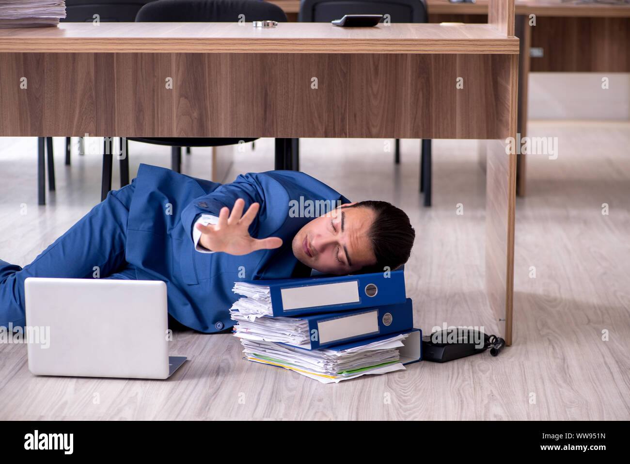 The young male employee and too many work in the office Stock Photo - Alamy