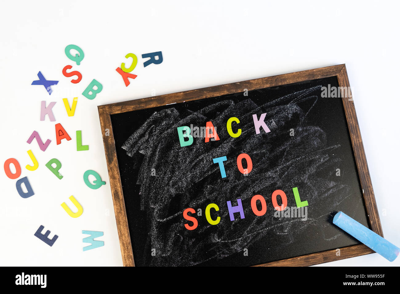 Blackboard with text back to school with loose colored letters on white ...