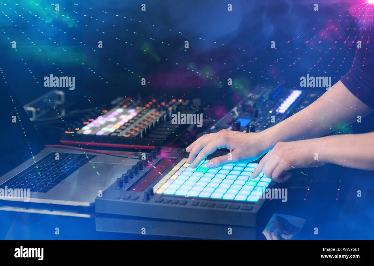 Hand mixing music on midi controller with party club colors around ...
