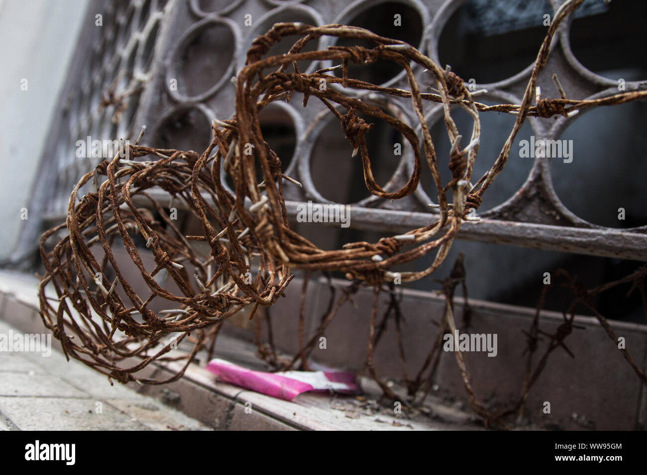 Sharp security barb wire fence barrier mesh next to colonial building ...