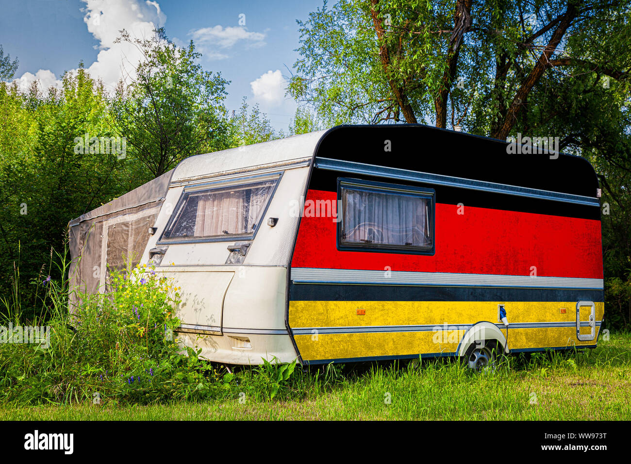 A car trailer, a motor home, painted in the national flag of Germany ...