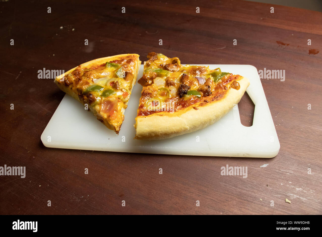 Pan Pizza slice on tray with dark brown wood top closeup Stock Photo ...
