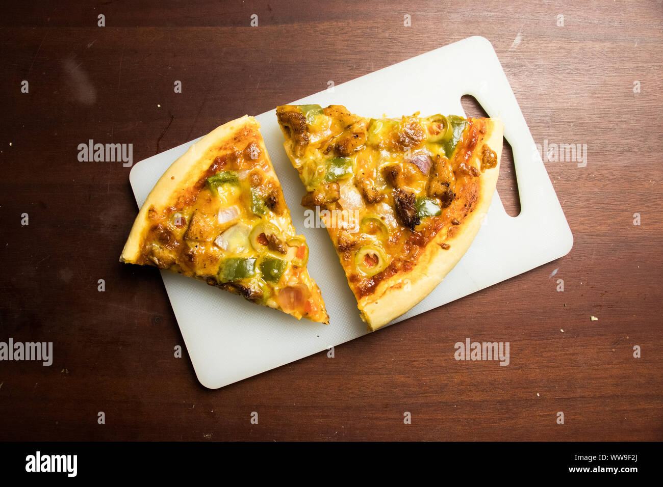 Pan Pizza slice on tray with dark brown wood top closeup Stock Photo ...