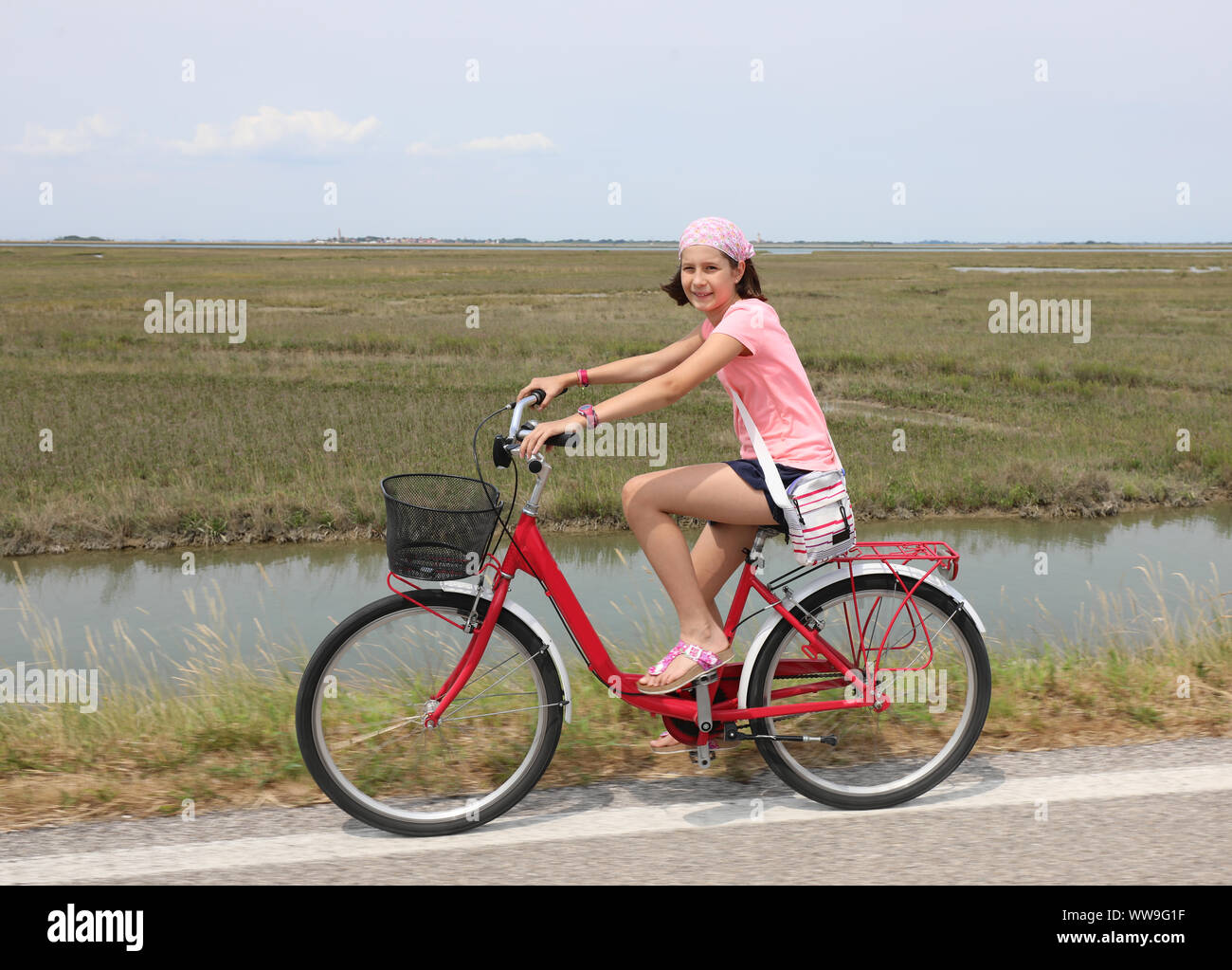 Pretty little girl with bandana on the bike in summer Stock Photo - Alamy