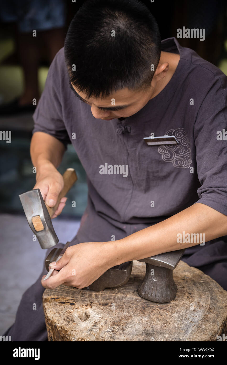 Xian, China - July 2019 : Man using hammer to make crafts on the street ...