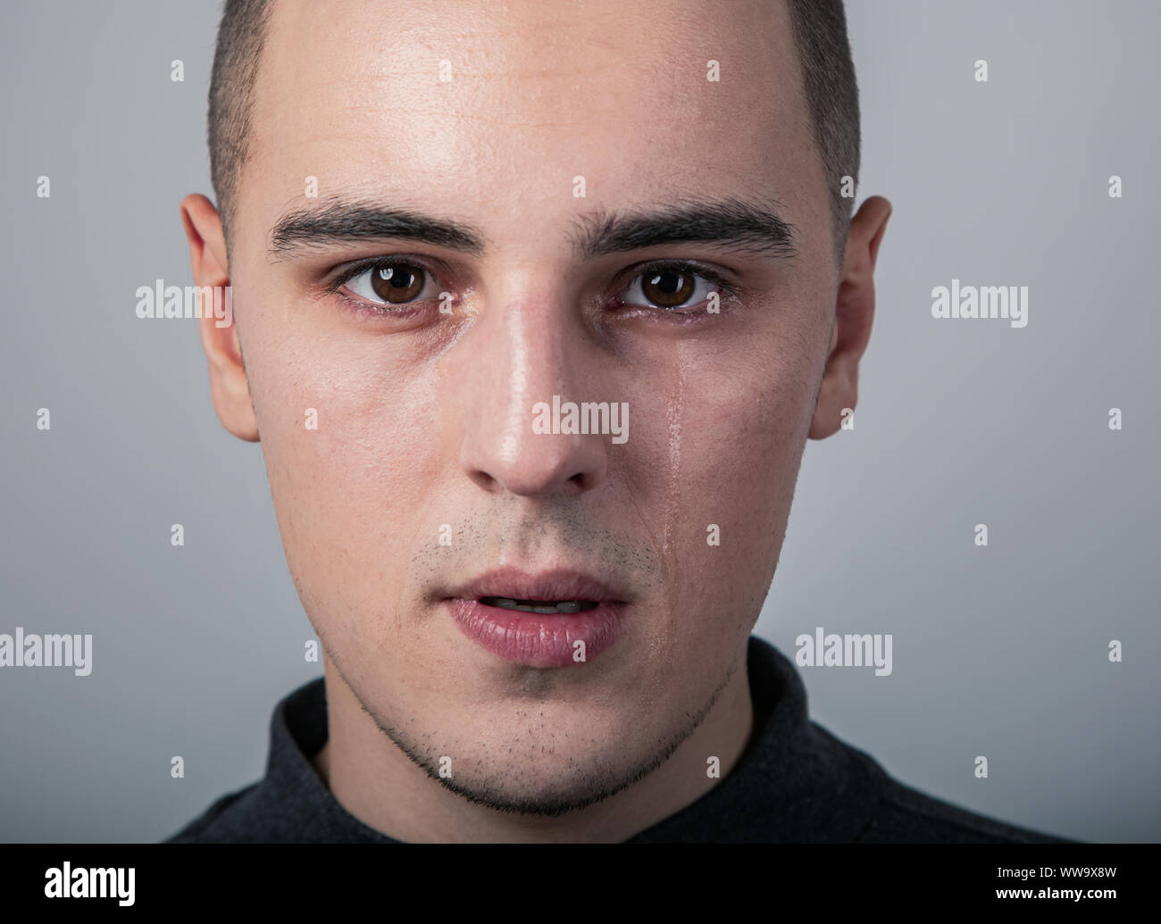 Unhappy crying young man with dropping tears on the face. Closeup ...