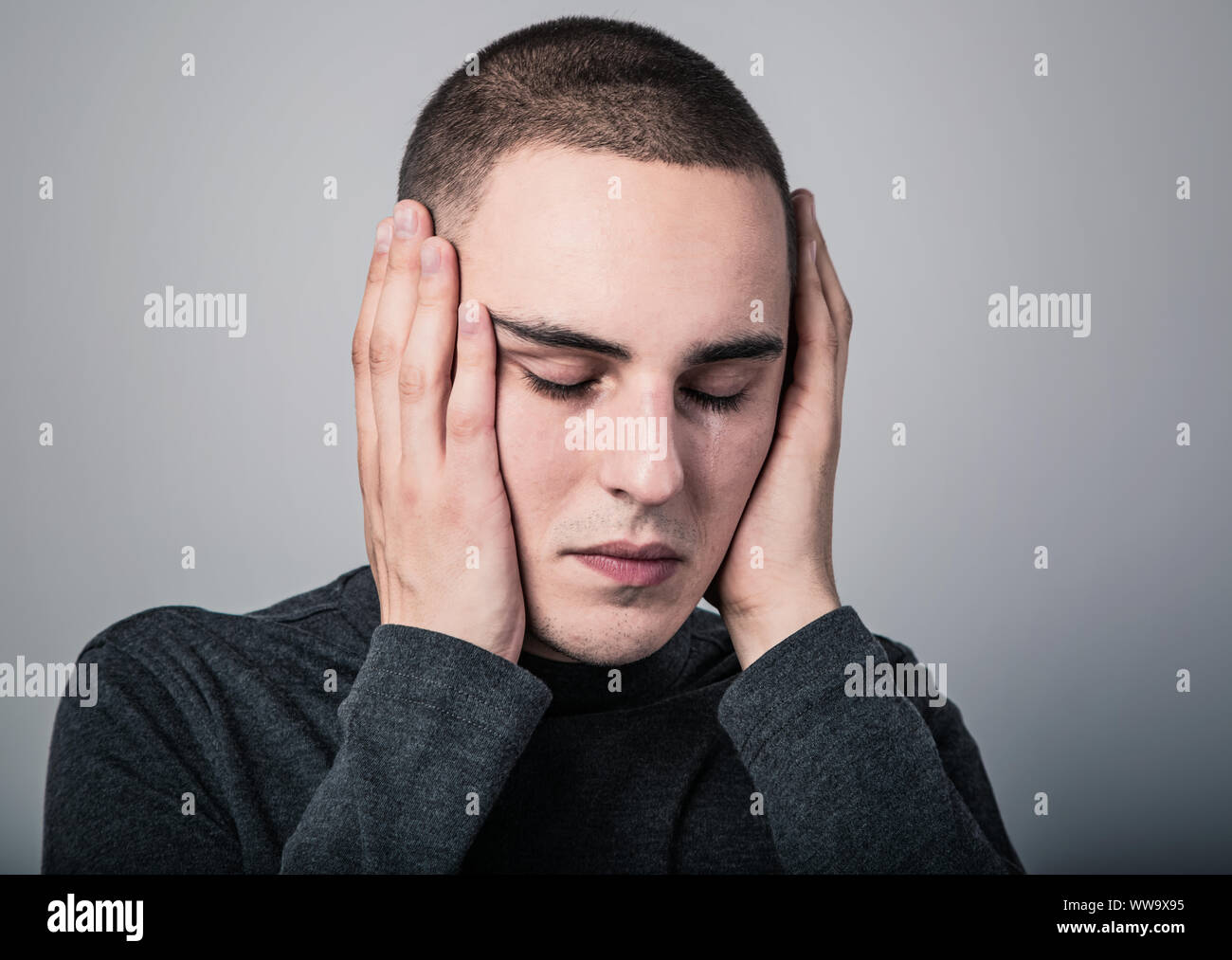 Unhappy crying man with dropping tears on the face with headache ...