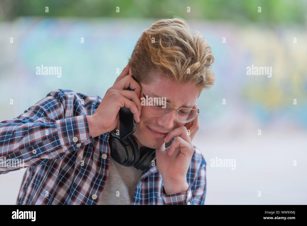 The face of a young man crying while talking on the phone Stock Photo ...