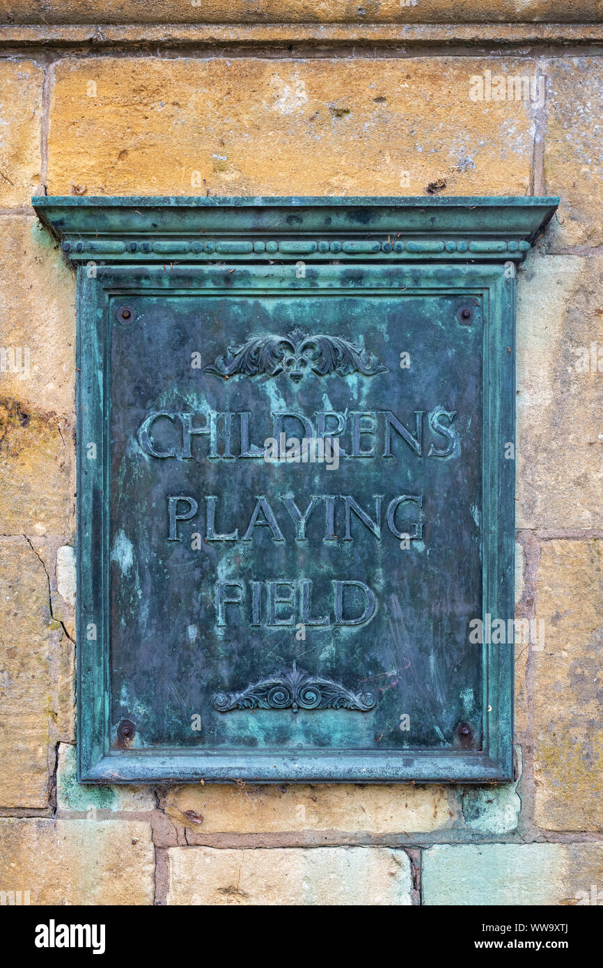Childrens playing field sign on a stone wall. Elmley Castle, Cotswolds ...
