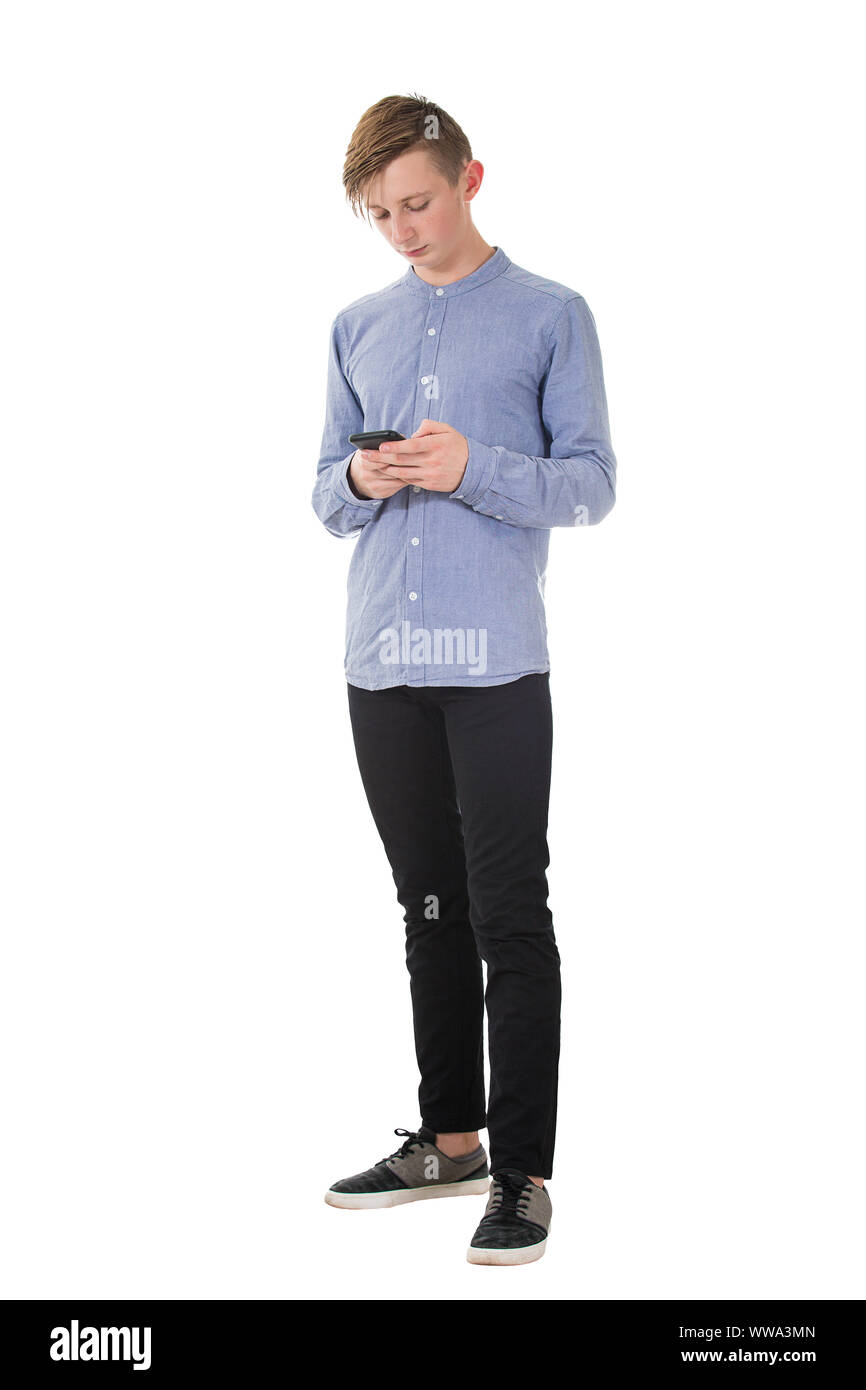 Full length portrait of teenage boy using his smartphone for texting ...