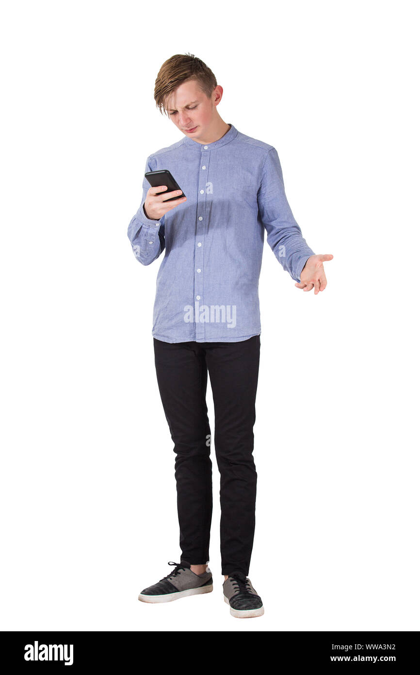 Full length portrait of angry adolescent boy using his mobile phone ...