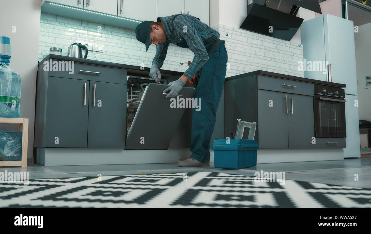 Full-length portrait of serious handyman wearing uniform standing in ...