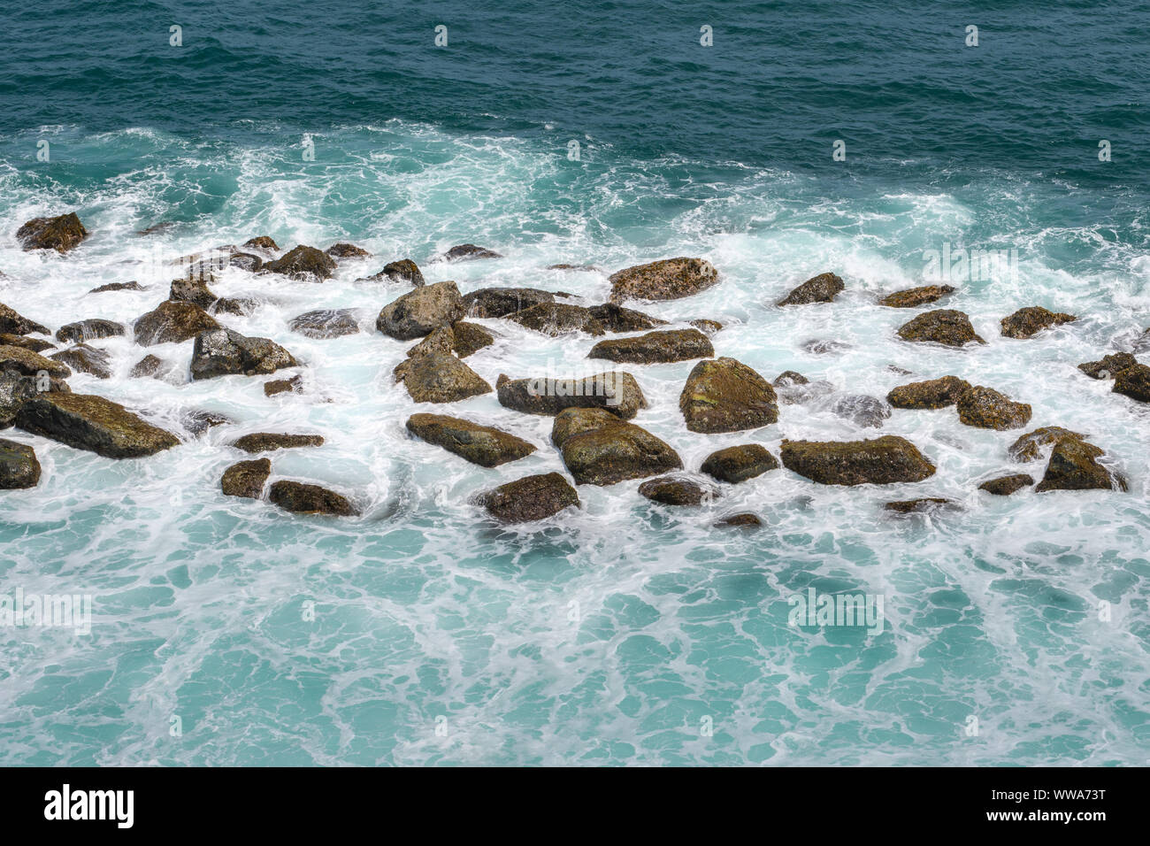 Reefs covered in white sea foam in blue ocean waves. Close-up. Concept ...