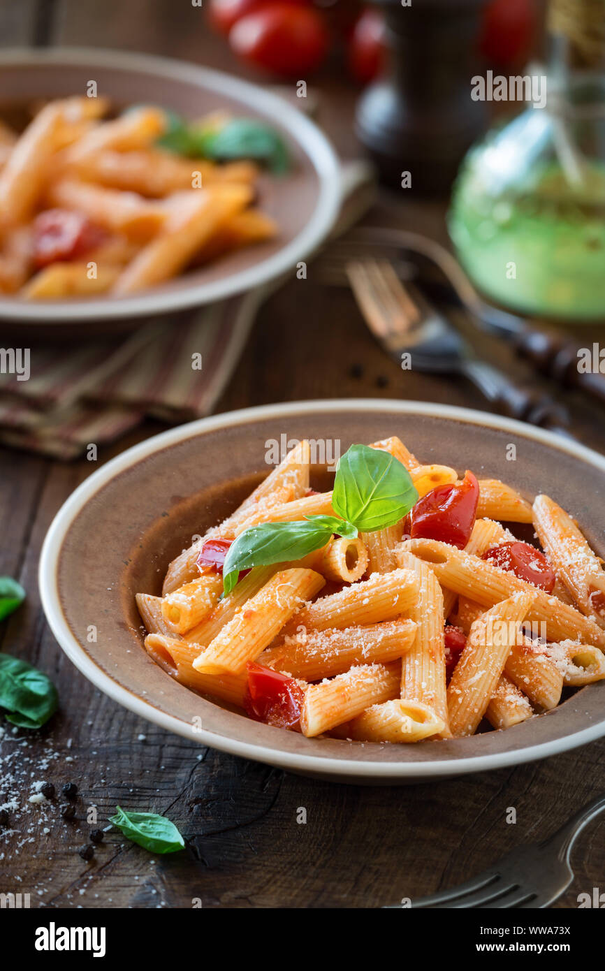 Plate of pasta penne with cherry tomato sauce, fresh basil and grated ...